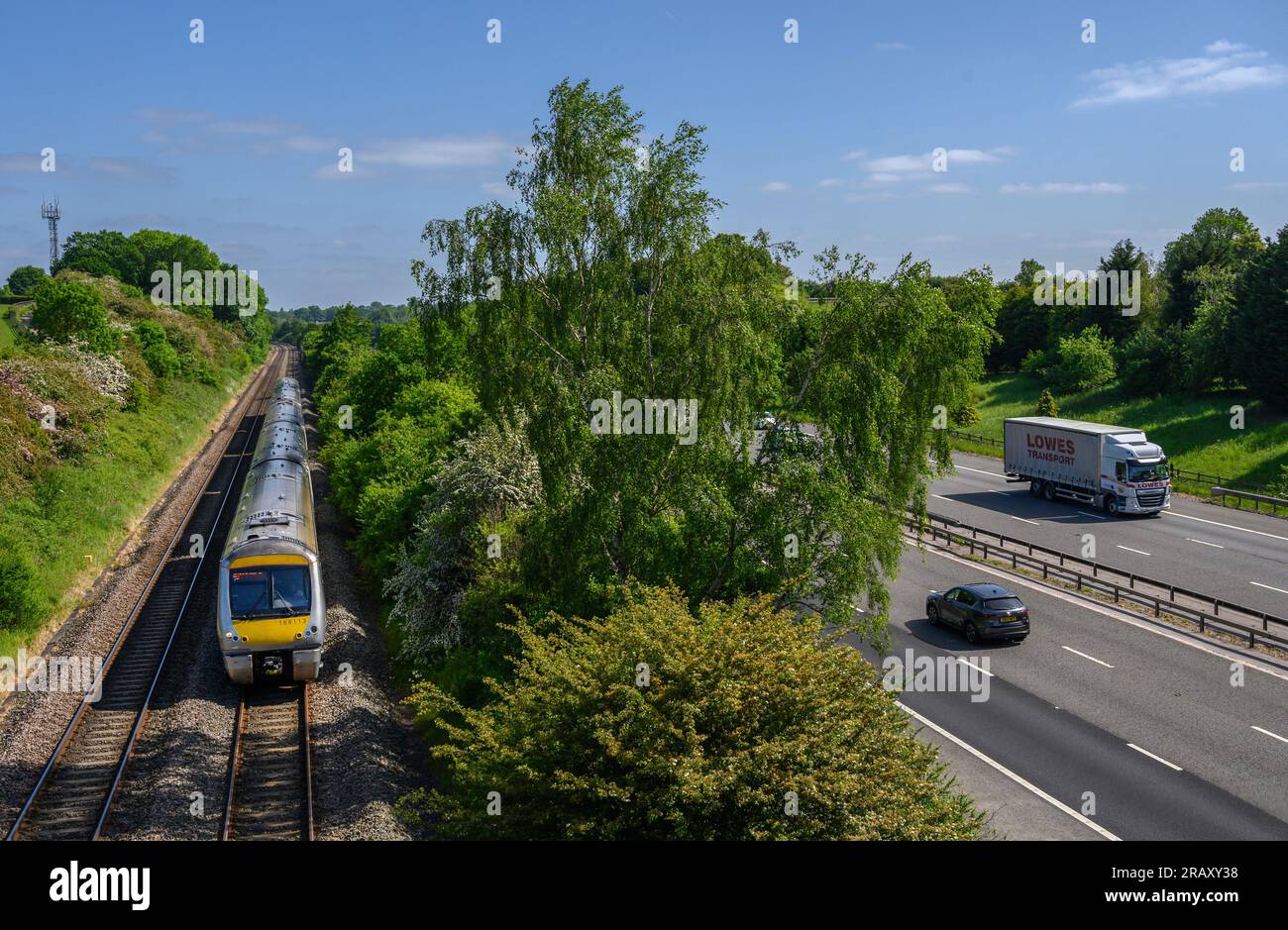 Train travelling along track running parallel with the M40 motorway, Warwickshire, England Stock ...
