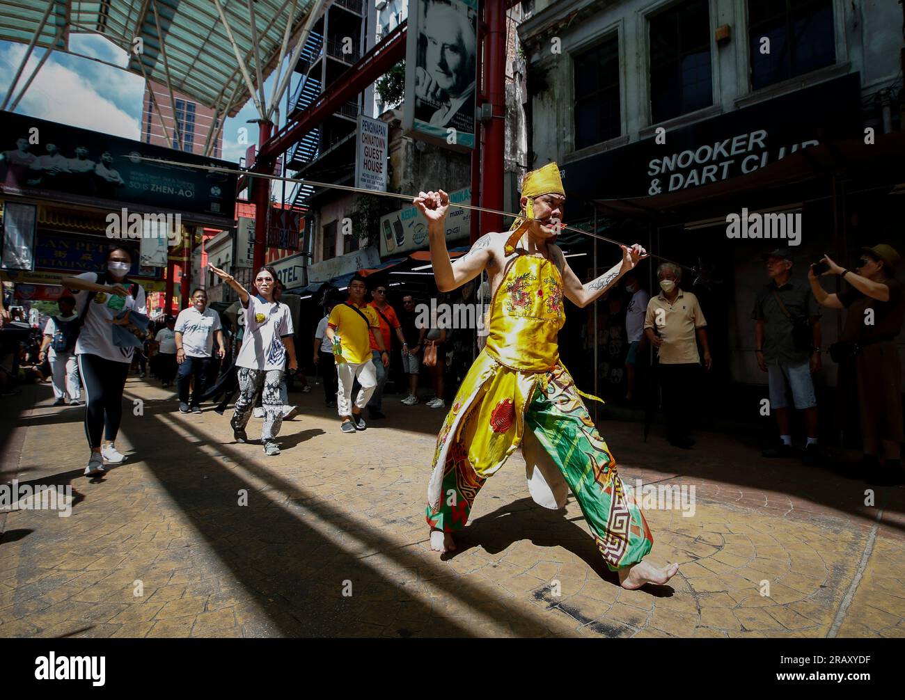 A devotee is pierced through the cheek with a metal rod joins a street ...