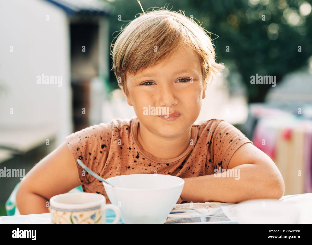 Adorable little boy having breakfast in sunny garden Stock Photo - Alamy