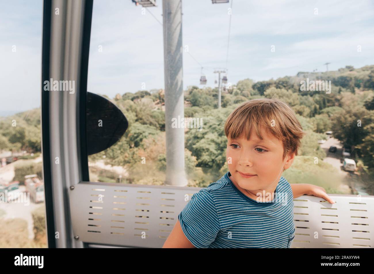 Cute little boy enjoying ride in cable car during summer vacation ...