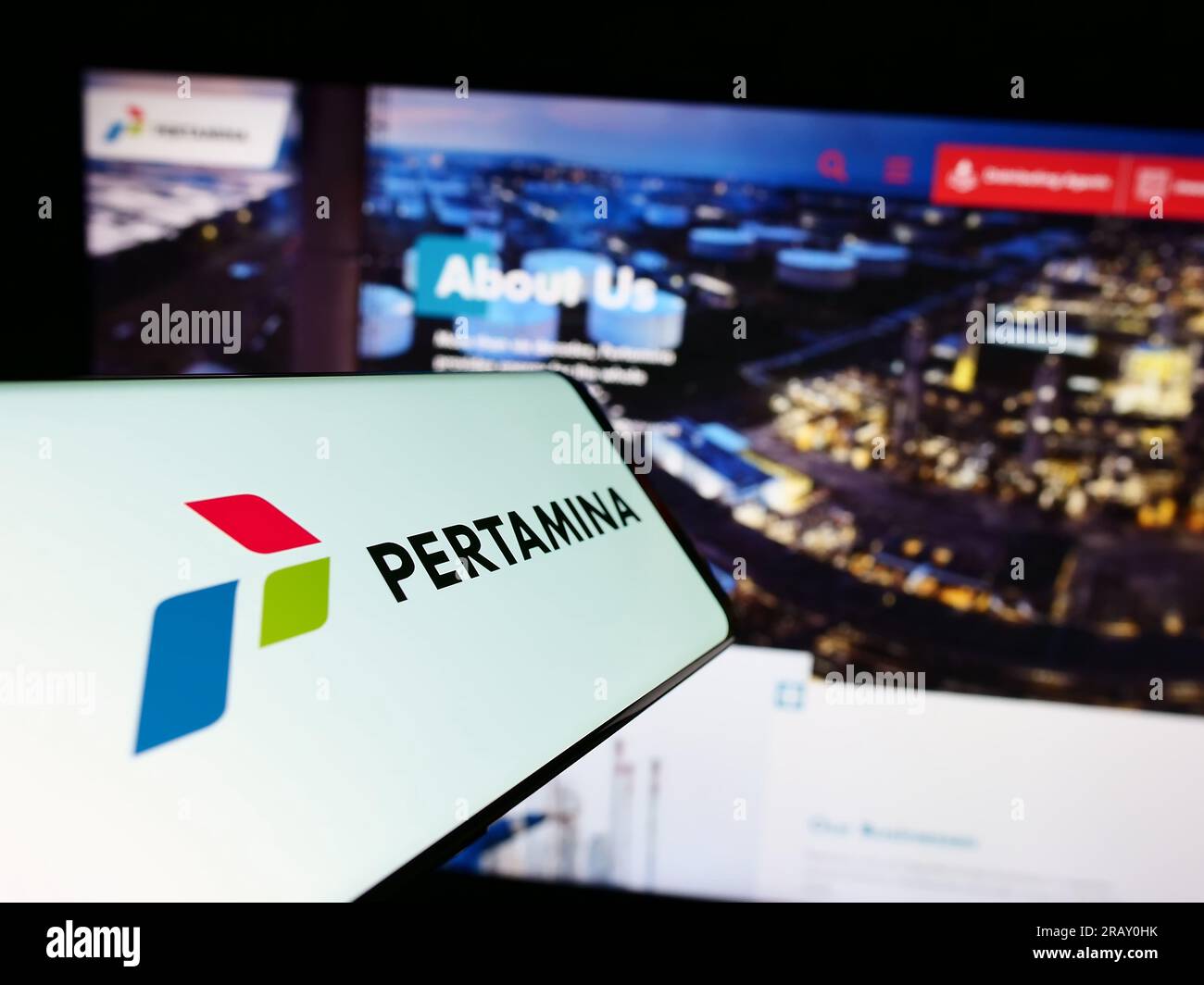 Mobile phone with logo of Indonesian company PT Pertamina (Persero) on screen in front of ...