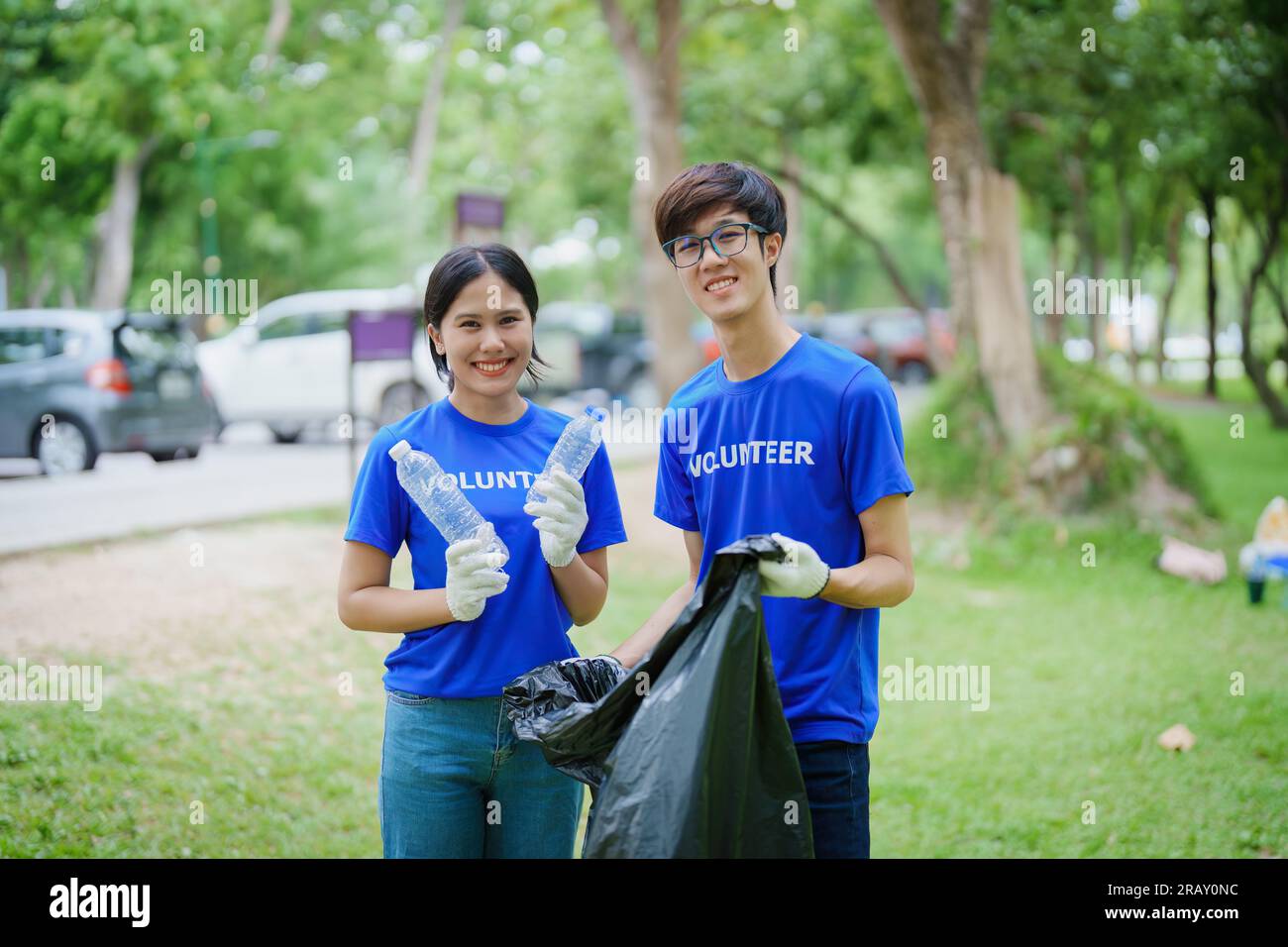 Multiethnic volunteers donate their time holding black garbage bags to ...