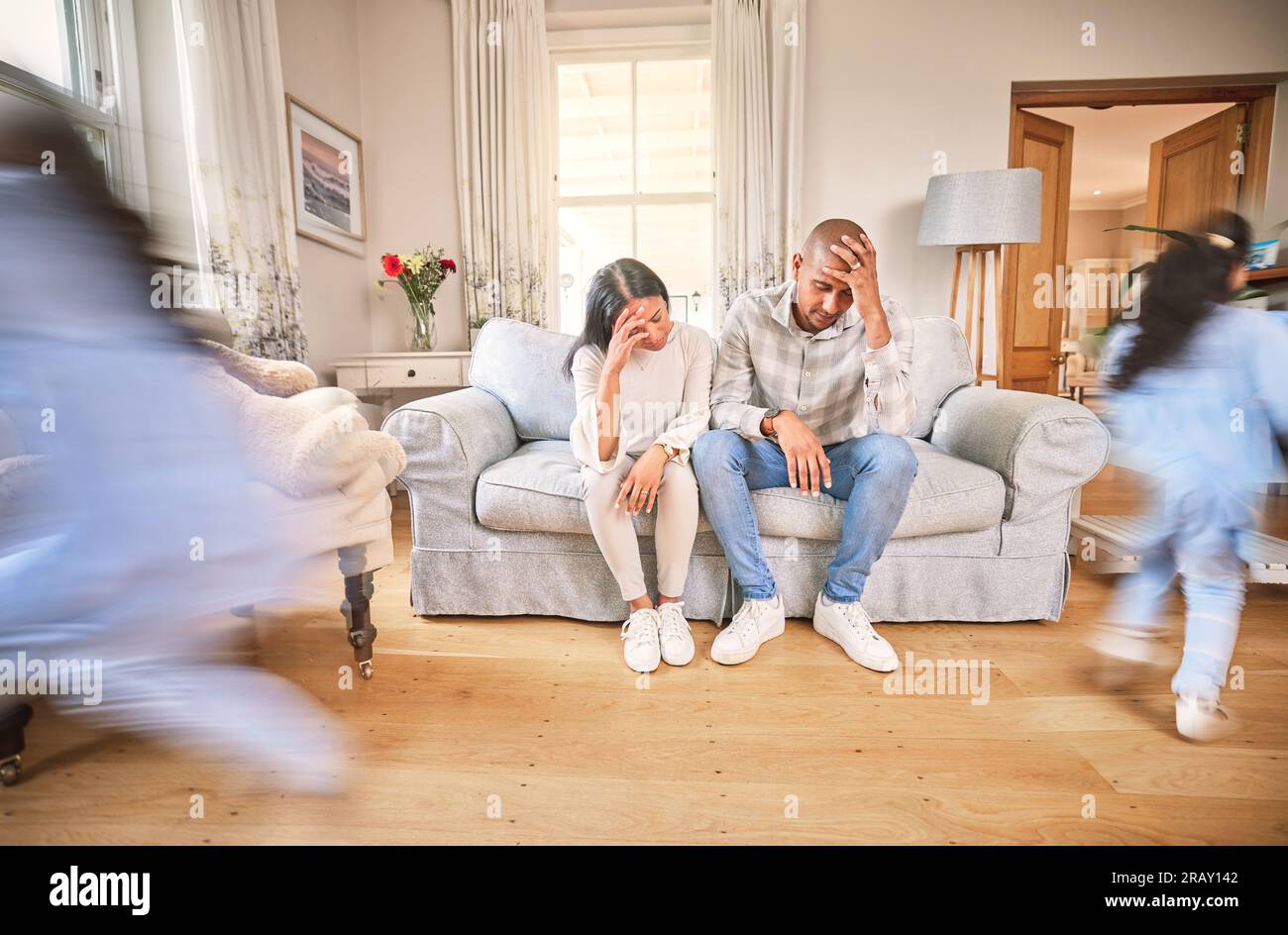 Motion blur, stress and parents with adhd children on a sofa in the ...