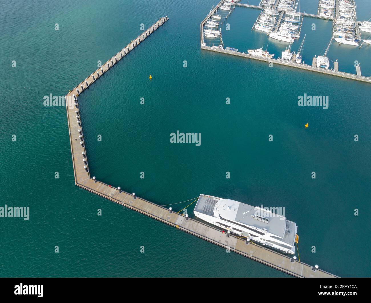 Aerial view of ferry anchored at a long angular jetty alongside a ...