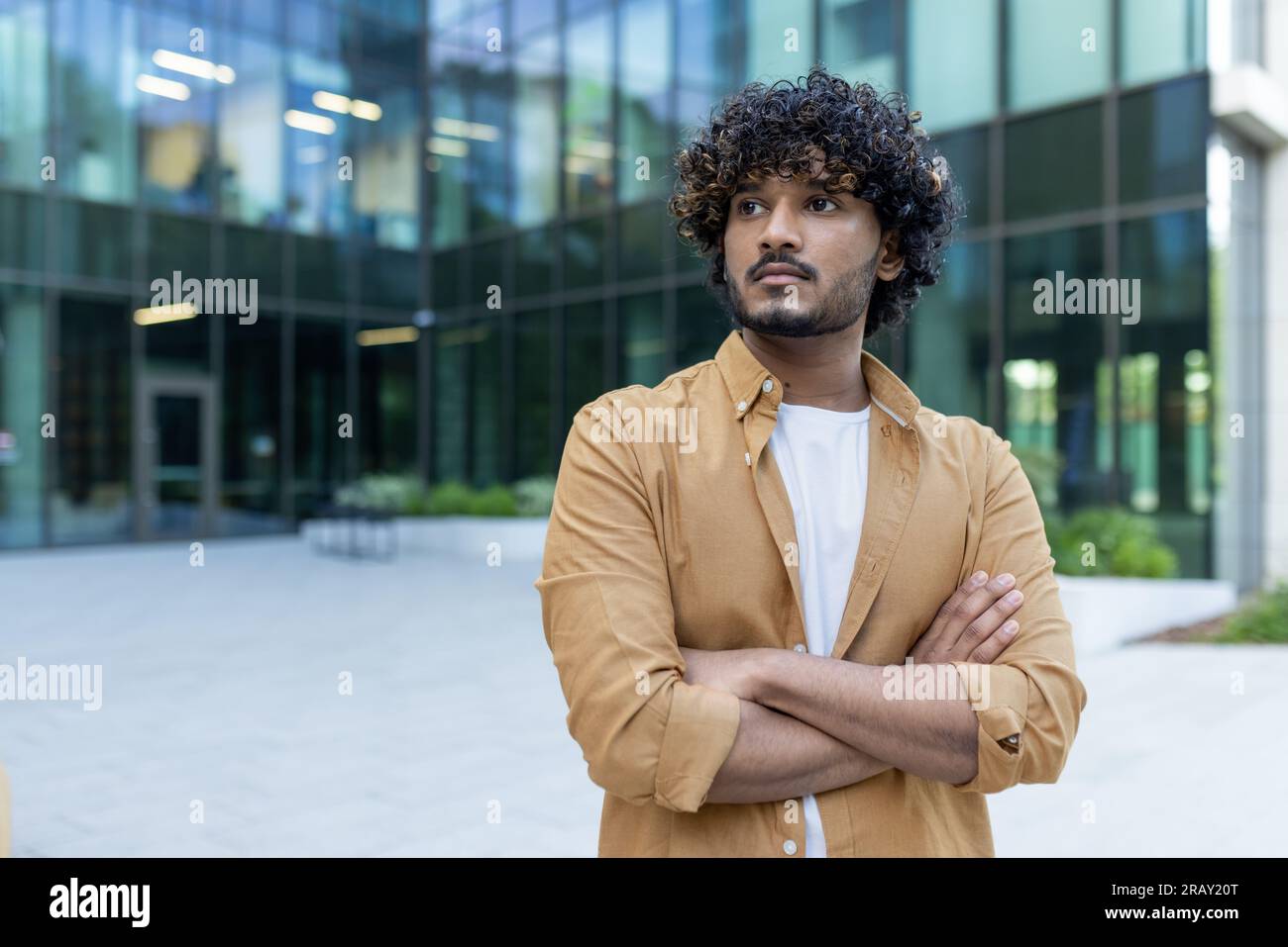 Portrait of a young Indian male programmer, developer standing with ...