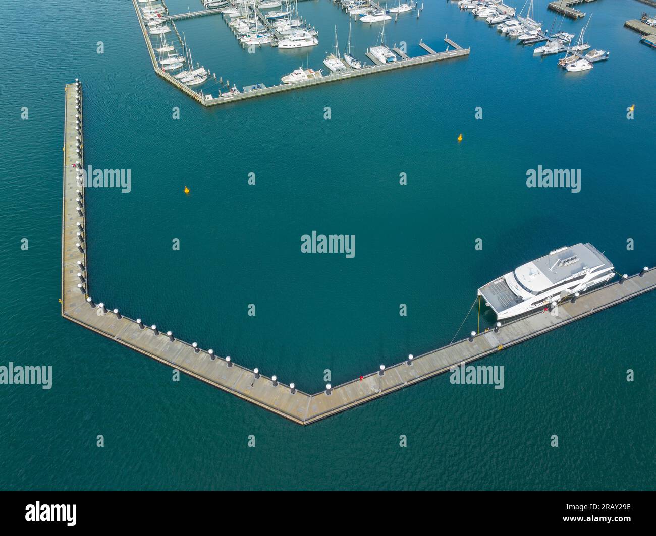 Aerial view of ferry anchored at a long angular jetty alongside a ...