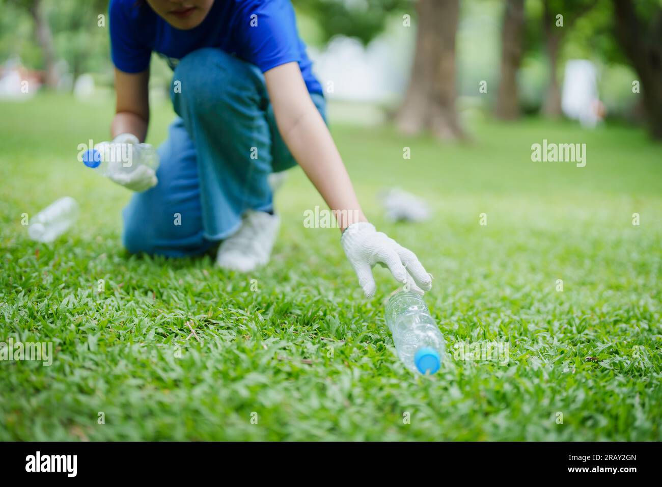 Multiethnic volunteers donate their time holding black garbage bags to ...