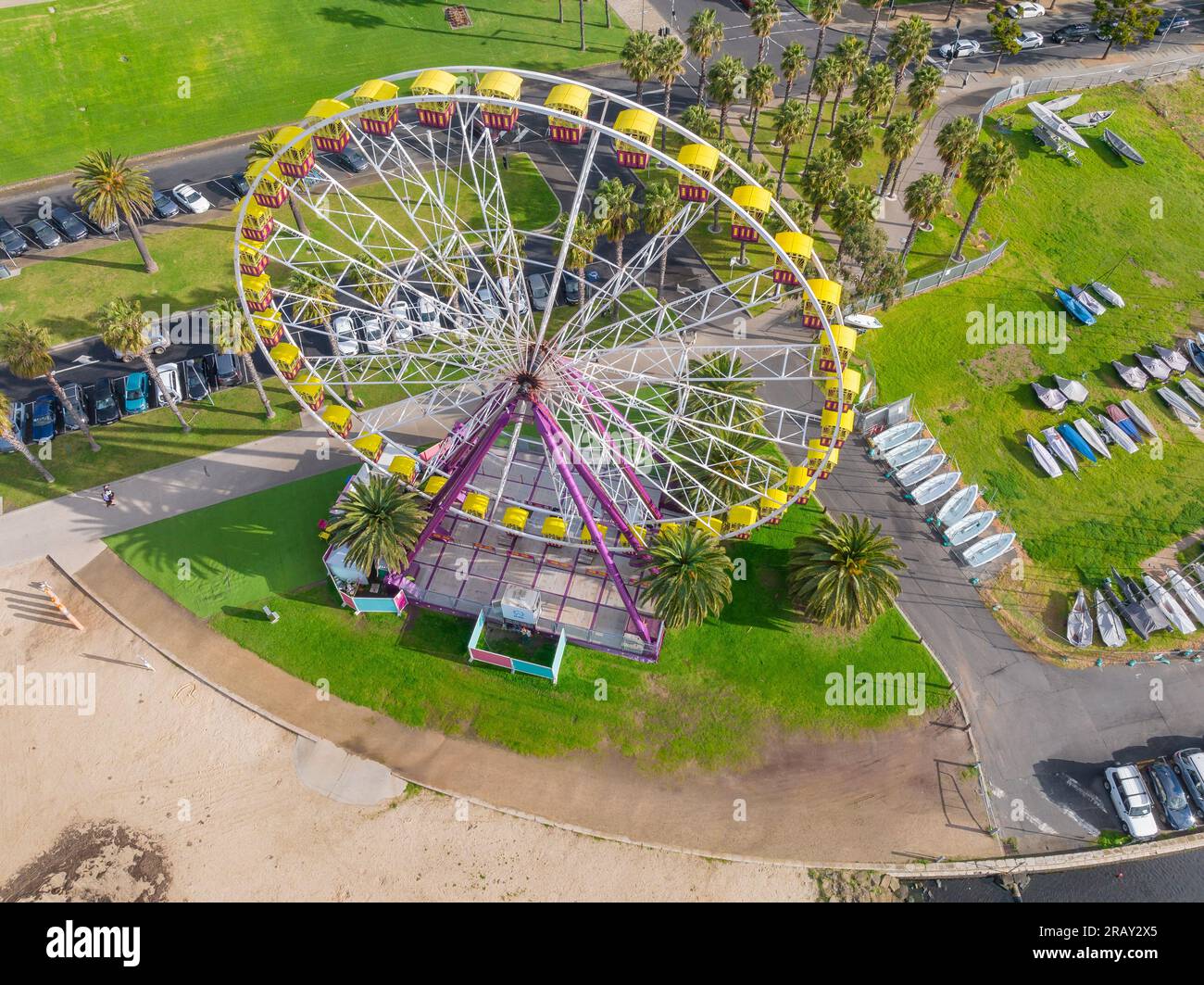 Aerial view of a ferris wheel surrounded by waterfront parkland and car ...