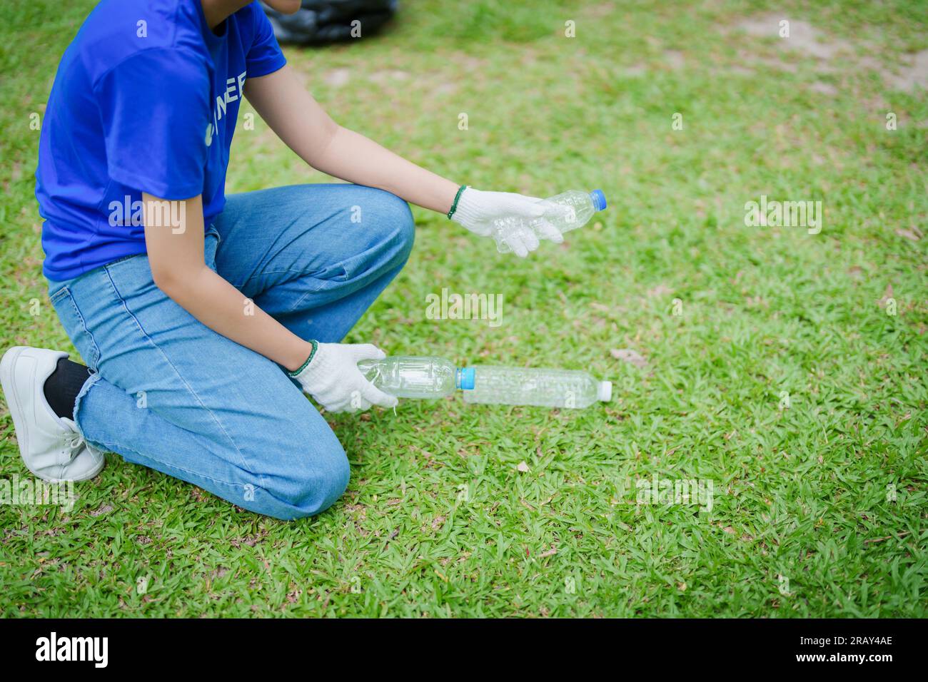 Multiethnic volunteers donate their time holding black garbage bags to ...