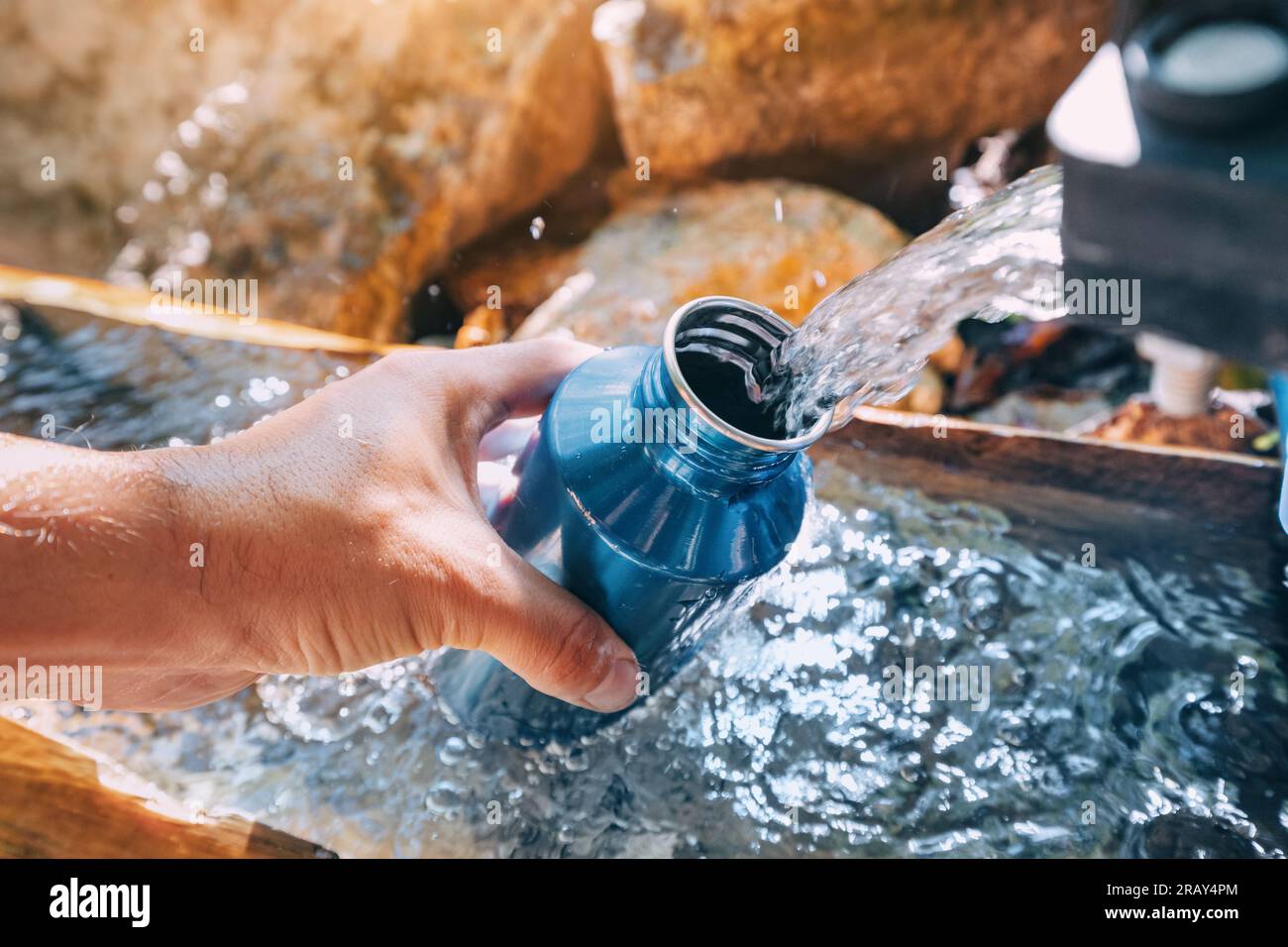 Pouring water from a spring source at camping or hiking. Clean looking ...