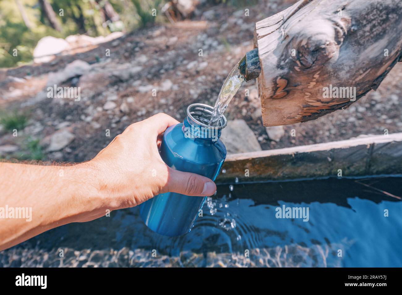 Pouring water from a spring source at camping or hiking. Clean looking ...
