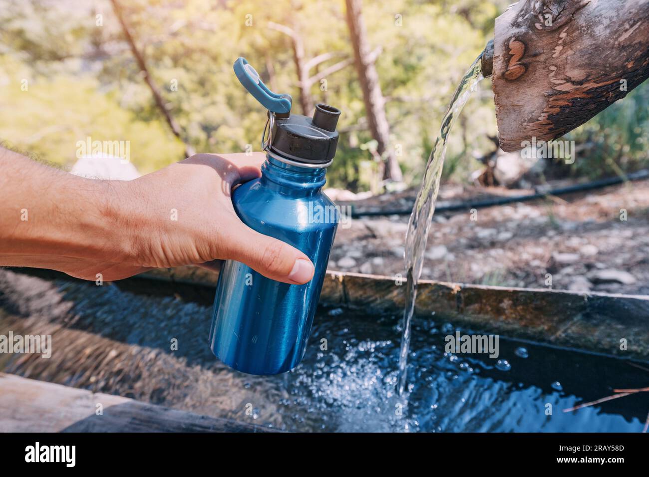 Pouring water from a spring source at camping or hiking. Clean looking ...