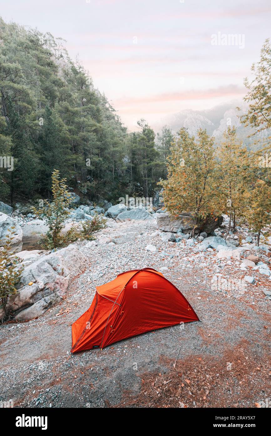 Red camping tent on a mountain trail. Travel outdoor recreation and ...