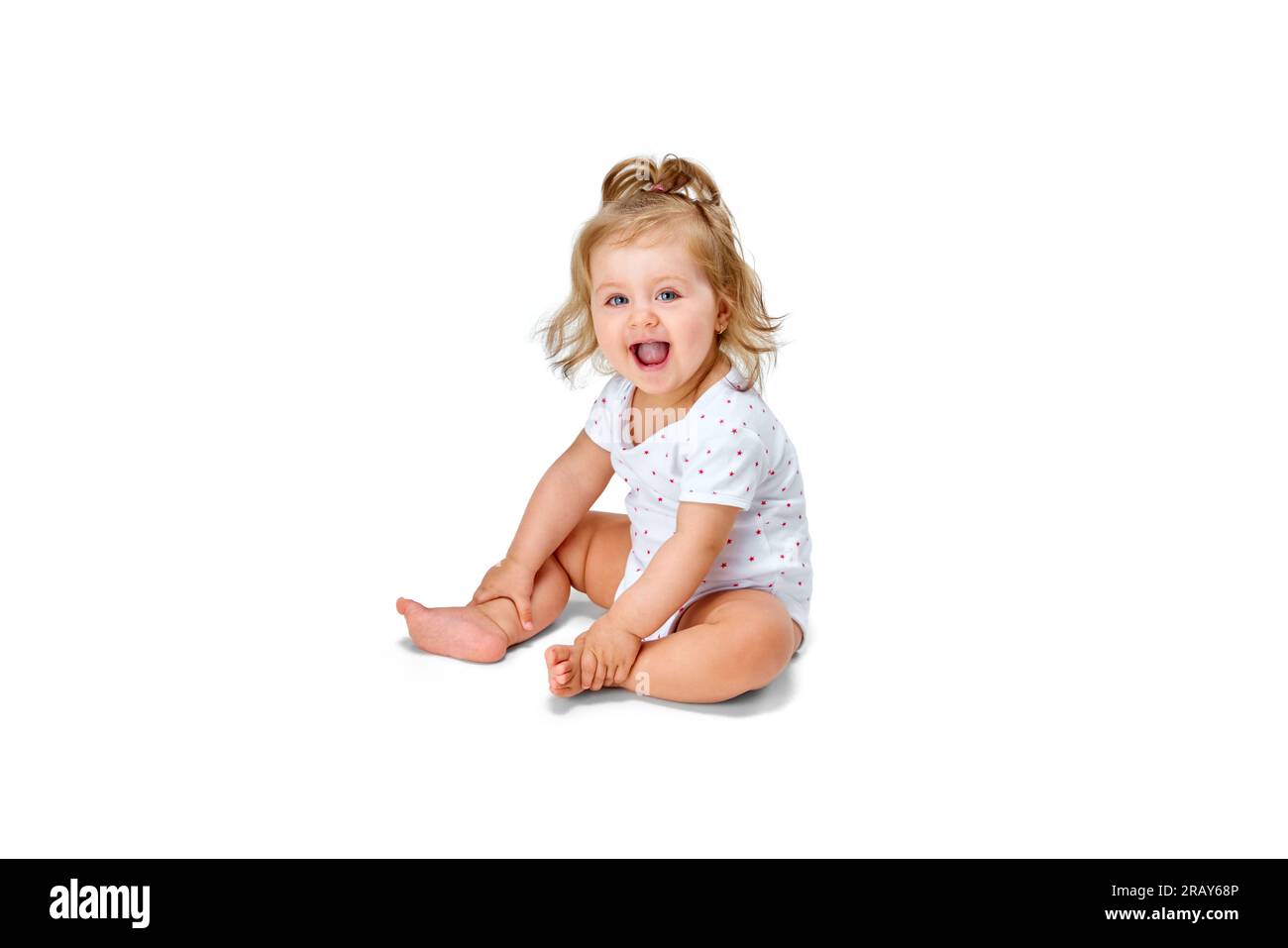 Happy, smiling child. Little baby girl, toddler sitting on floor and cheerfully laughing against ...