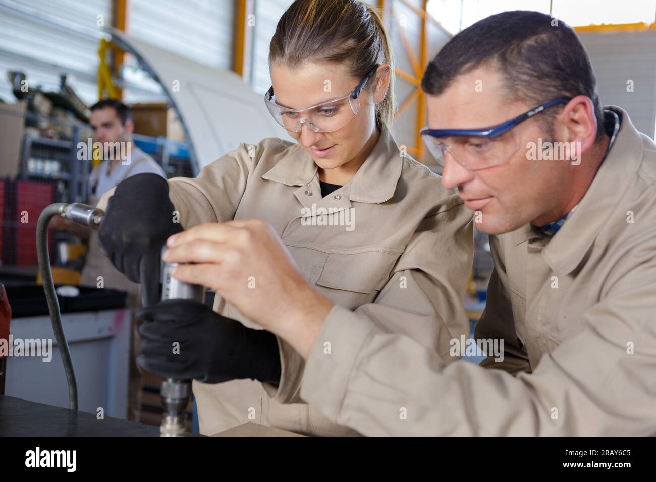 female apprentice using industrial polisher Stock Photo - Alamy