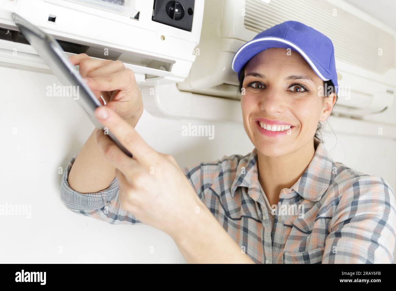 happy female worker repairing air conditioner Stock Photo - Alamy
