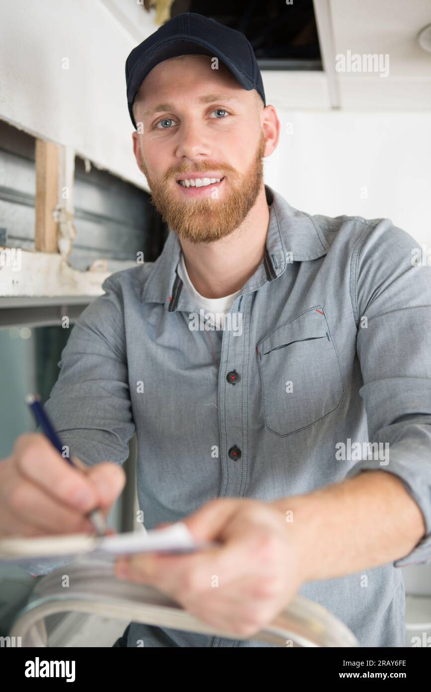 young tradesman writing notes Stock Photo - Alamy
