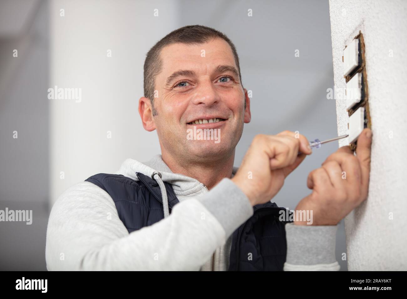 builder installing a triple lightswitch Stock Photo - Alamy