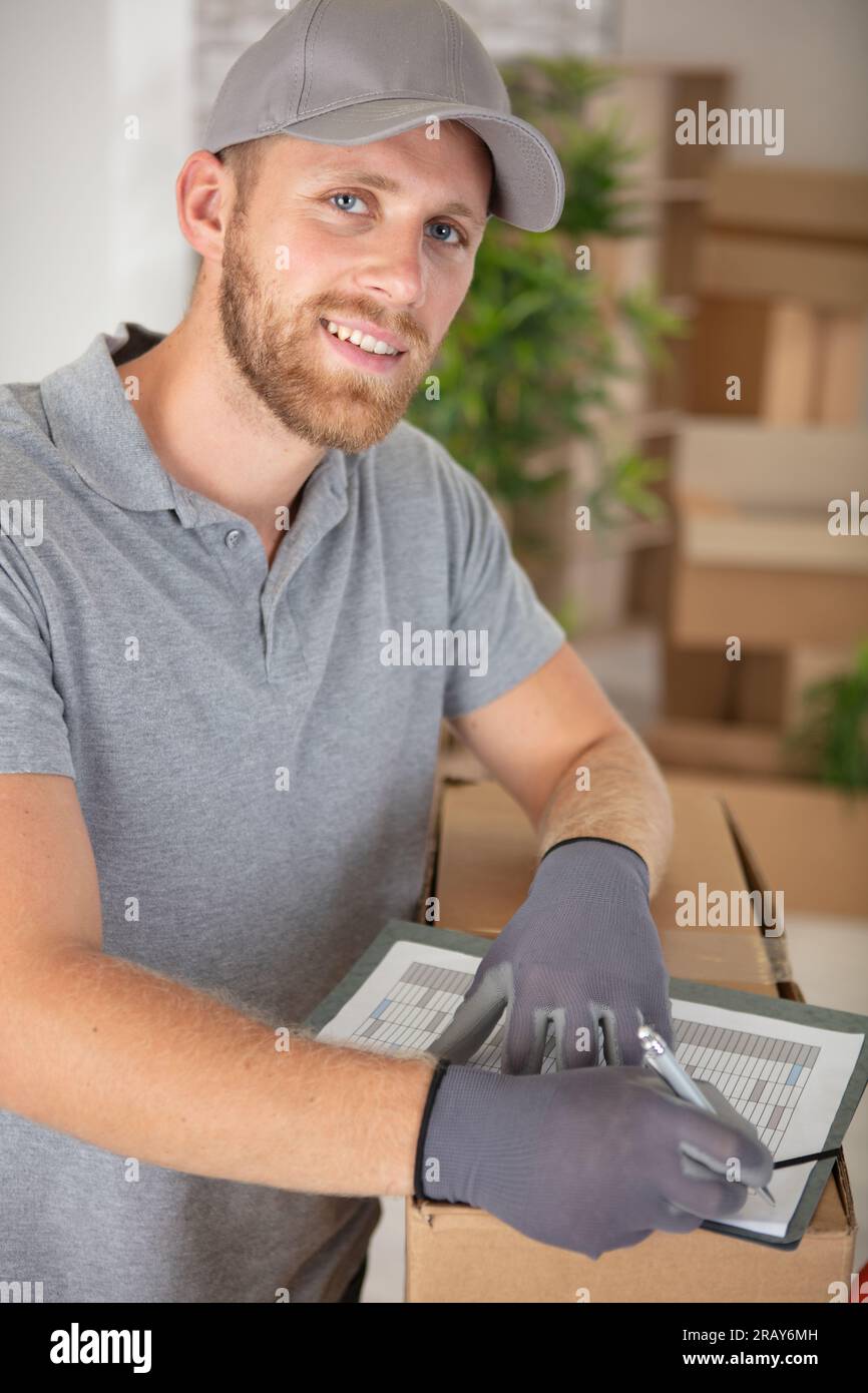 portrait of a relocation agent marking items on checklist Stock Photo ...