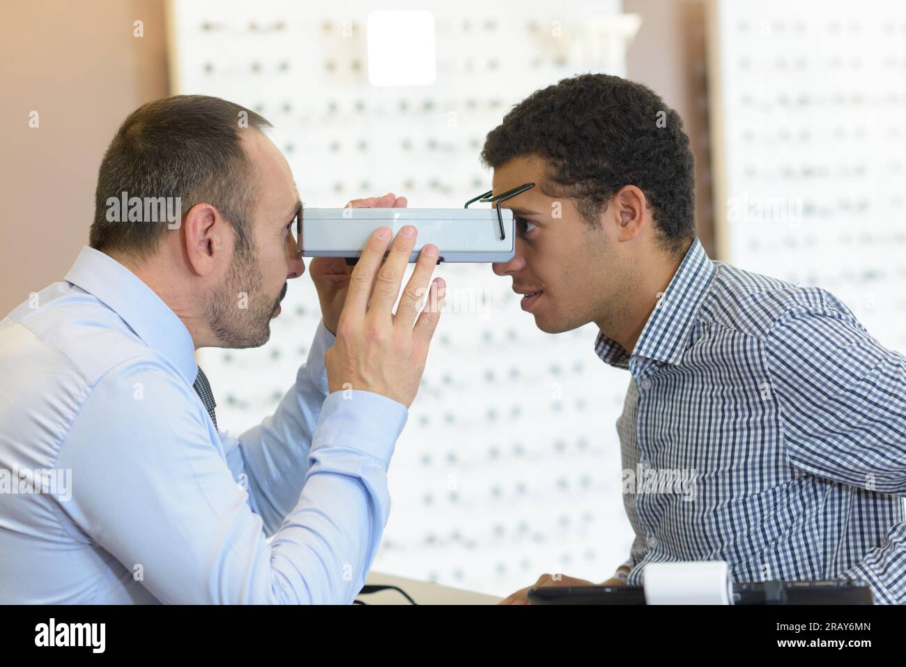 man looking at refractometer eye test machine Stock Photo - Alamy