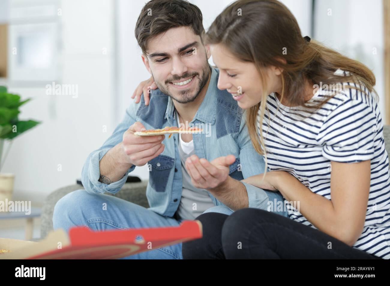 Couple sharing pizza eating together hi-res stock photography and ...