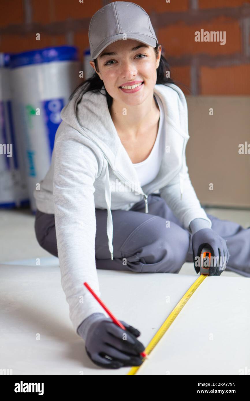 professional female manual worker using a tape measure Stock Photo - Alamy