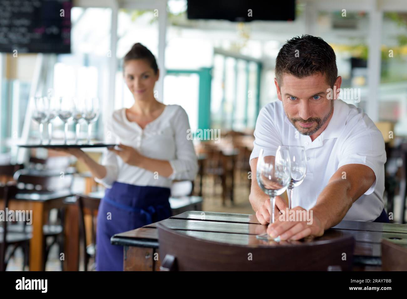 waiter placing glasses in restaurant Stock Photo - Alamy