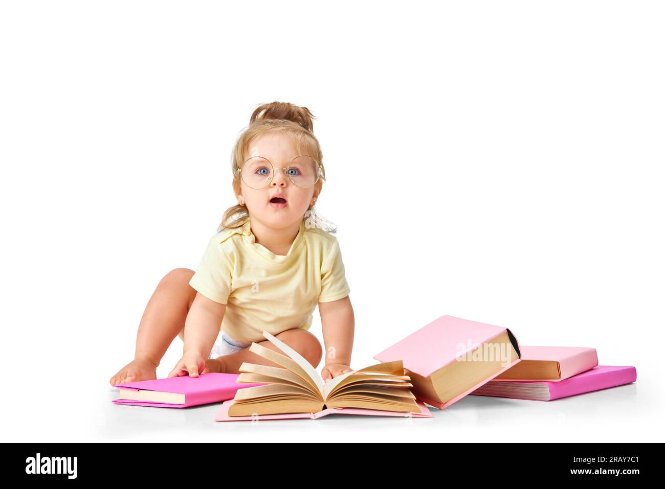 Smart, curious baby. Little girl, toddler sitting on floor with many ...