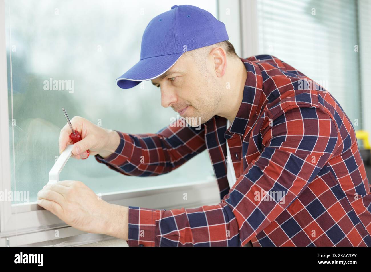 worker fasten the handle to a plastic window Stock Photo - Alamy