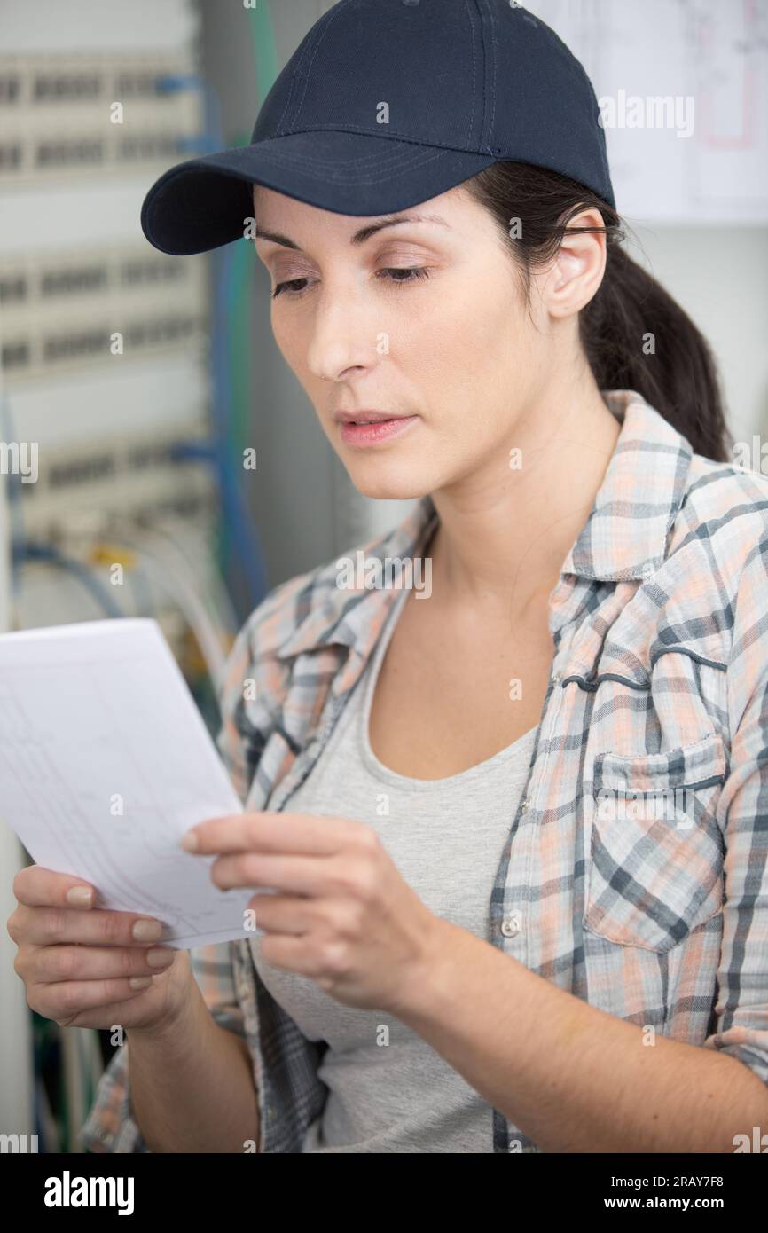 female technician reading instruction book Stock Photo - Alamy