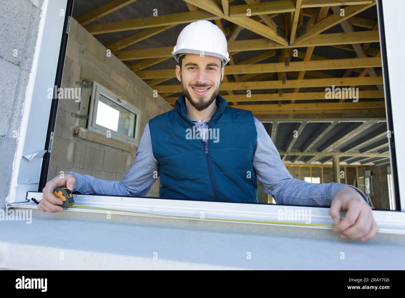 handsome young man installing window in new house construction site ...