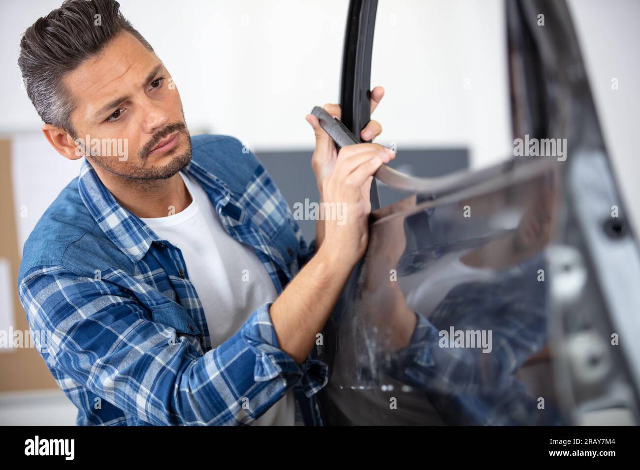 mechanic fitting a door rubber Stock Photo - Alamy