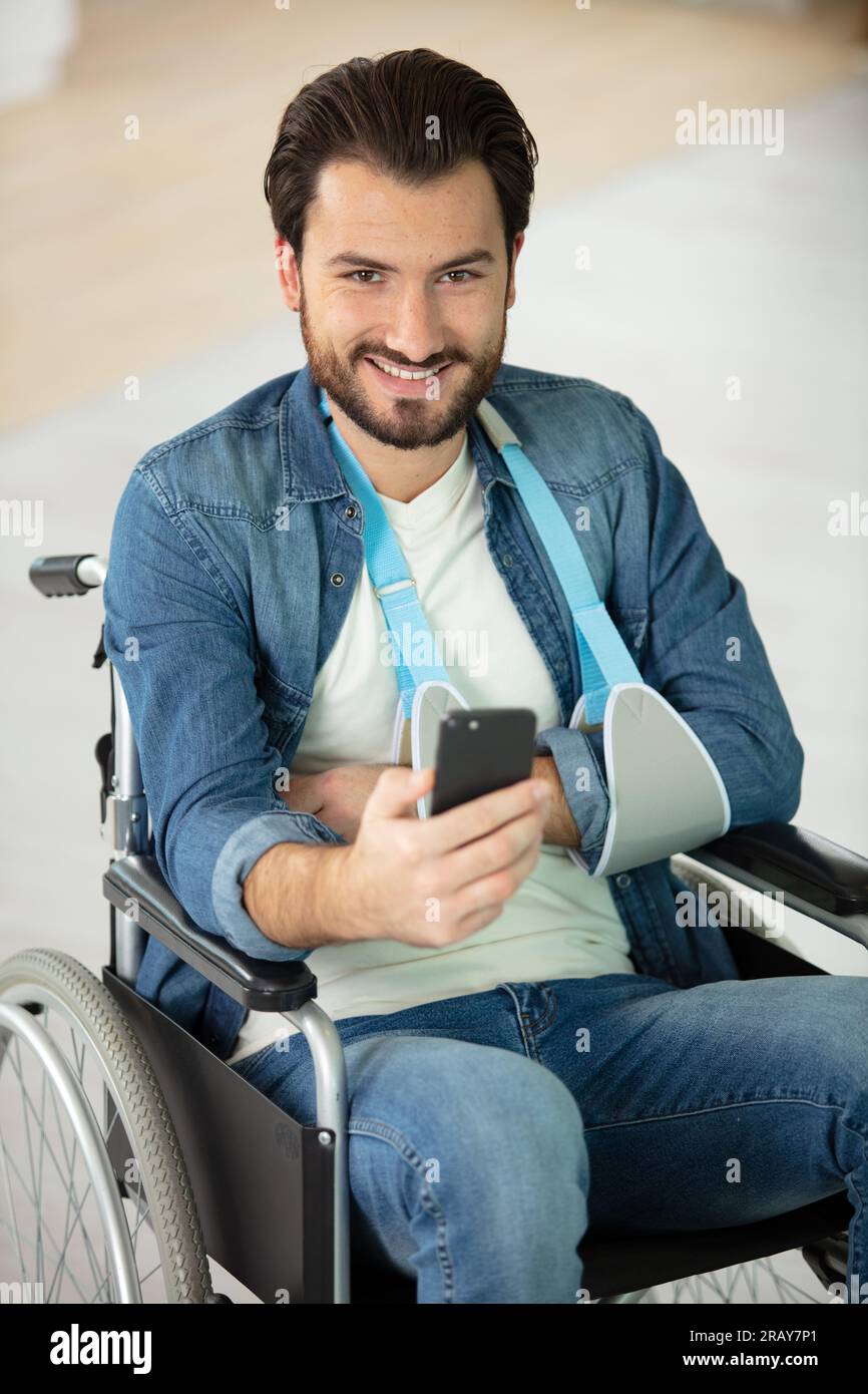 handsome man in wheelchair talking on his phone and smiles Stock Photo ...