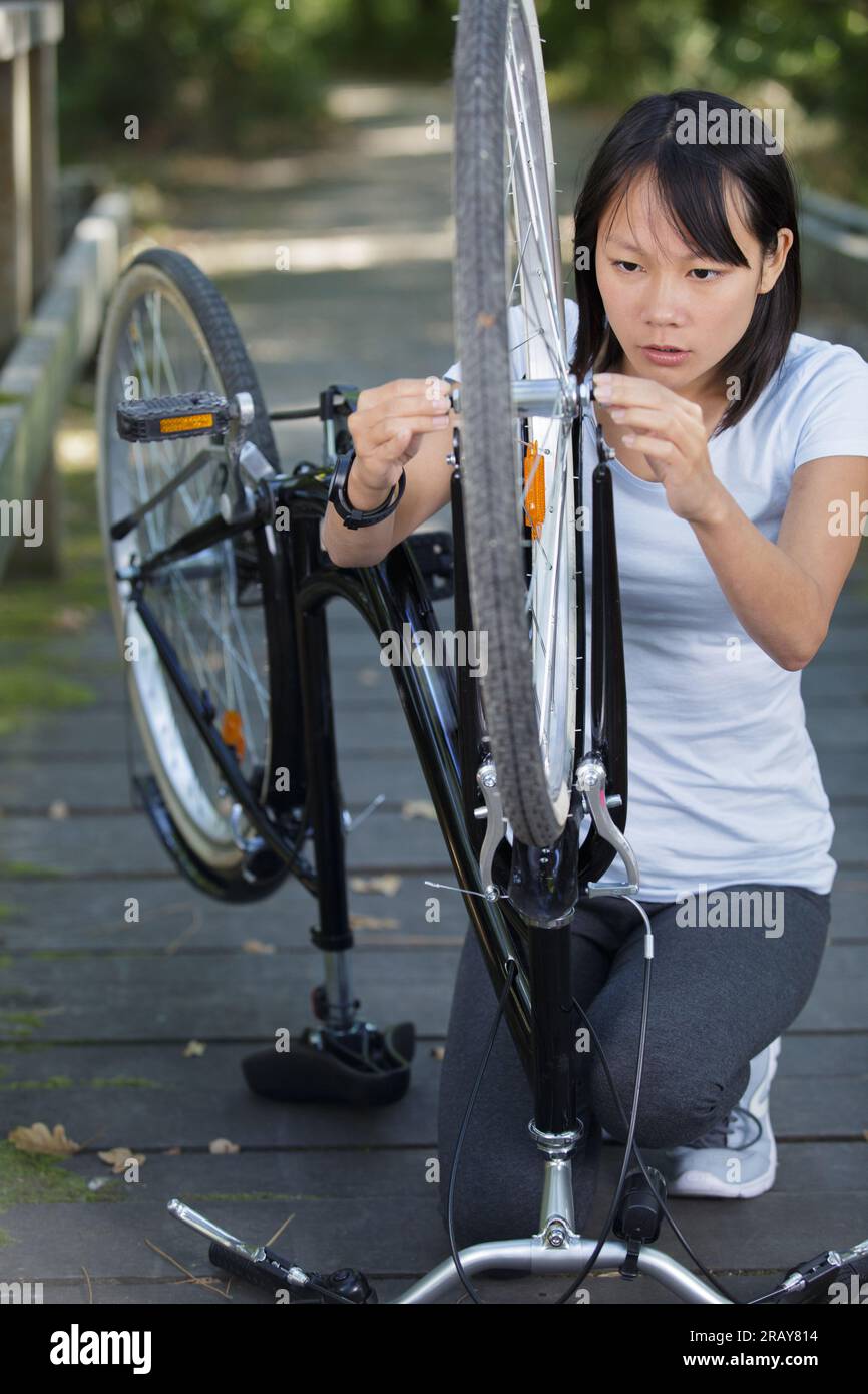 Close up woman fixing bicycle hi-res stock photography and images - Alamy