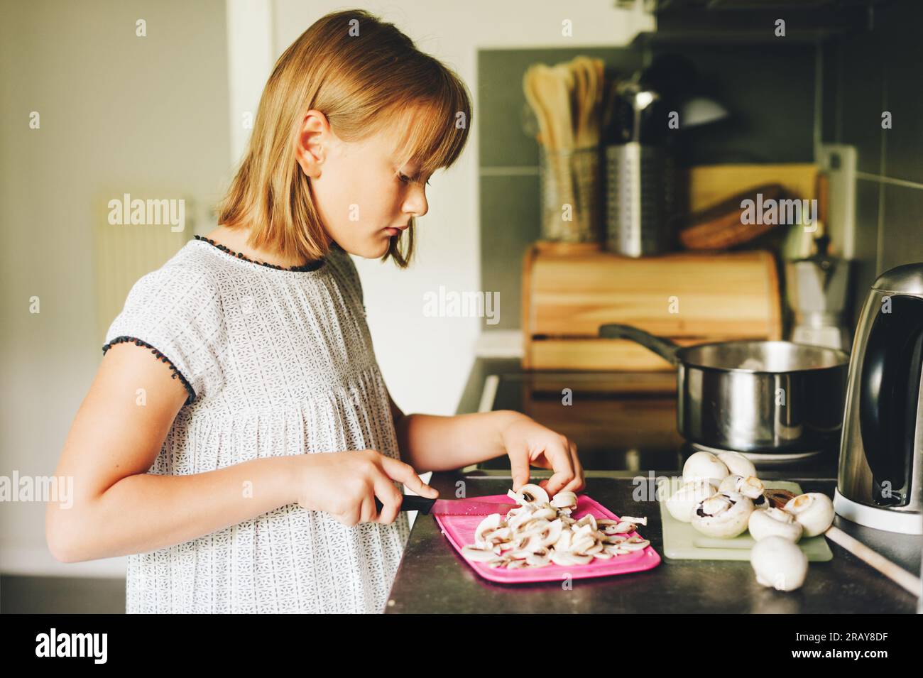 Cute little girl cooking vegetable lunch for the family, kid helping in ...