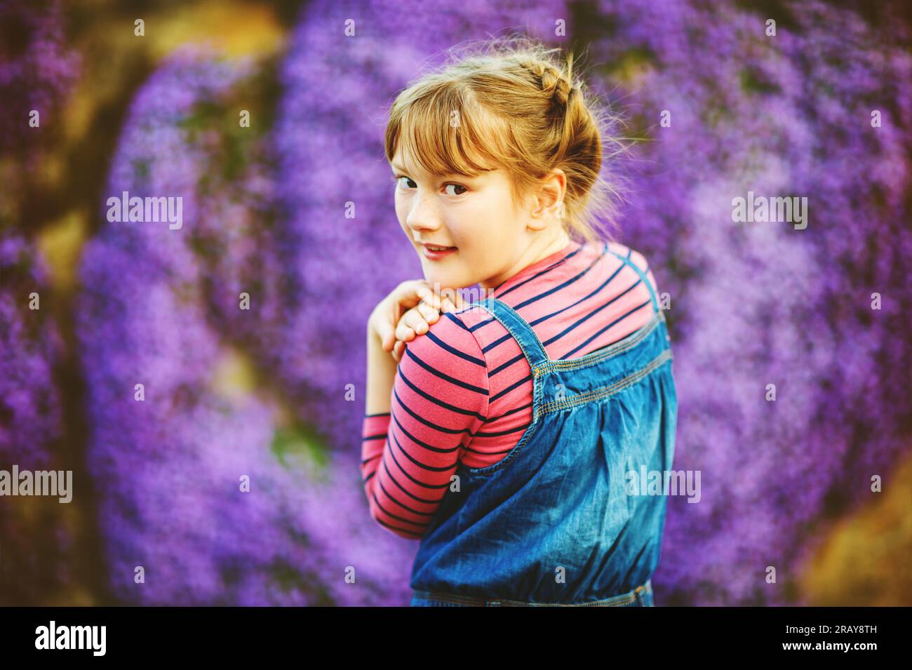 Summer portrait of young happy kid girl wearing denim overalls, looking ...