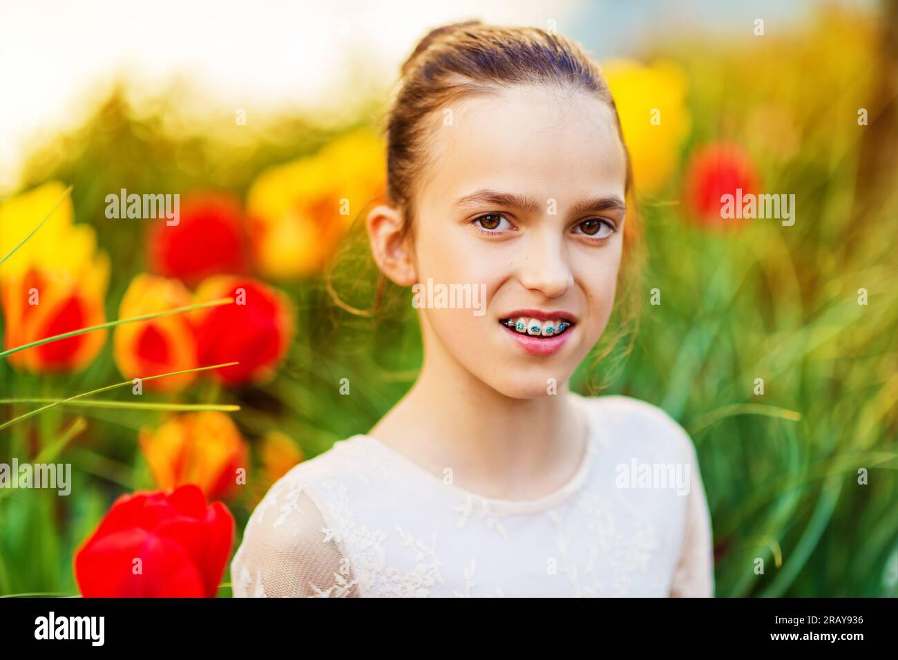 Spring portrait of sweet little girl wearing party dress, sitting ...