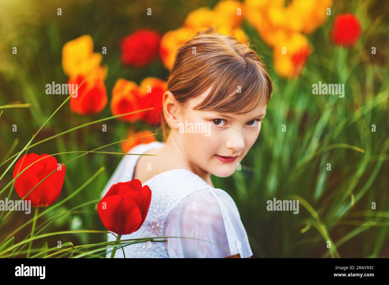 Spring portrait of sweet little girl wearing party dress, sitting ...