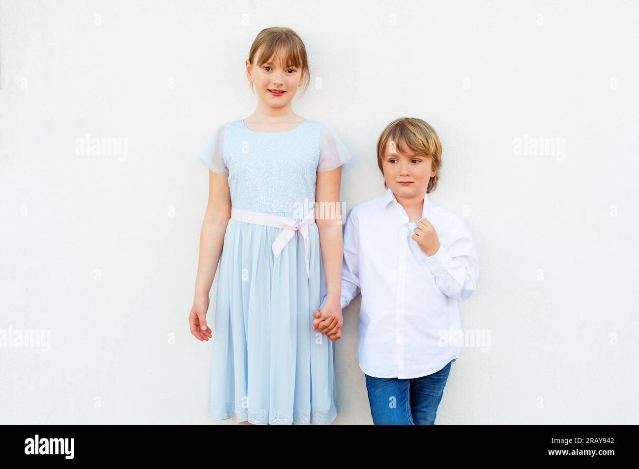 Group of two kids, girl and boy, wearing party clothes, standing ...