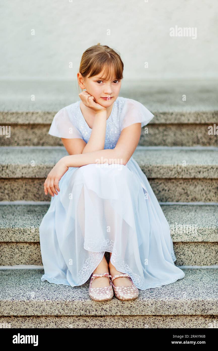 Sweet little preteen girl wearing party dress, sitting on stairs Stock Photo - Alamy
