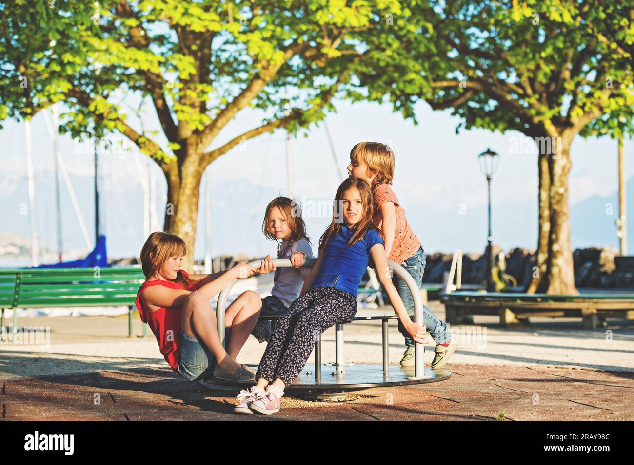 Group of four kids having fun on playground. Stylish kids playing on ...
