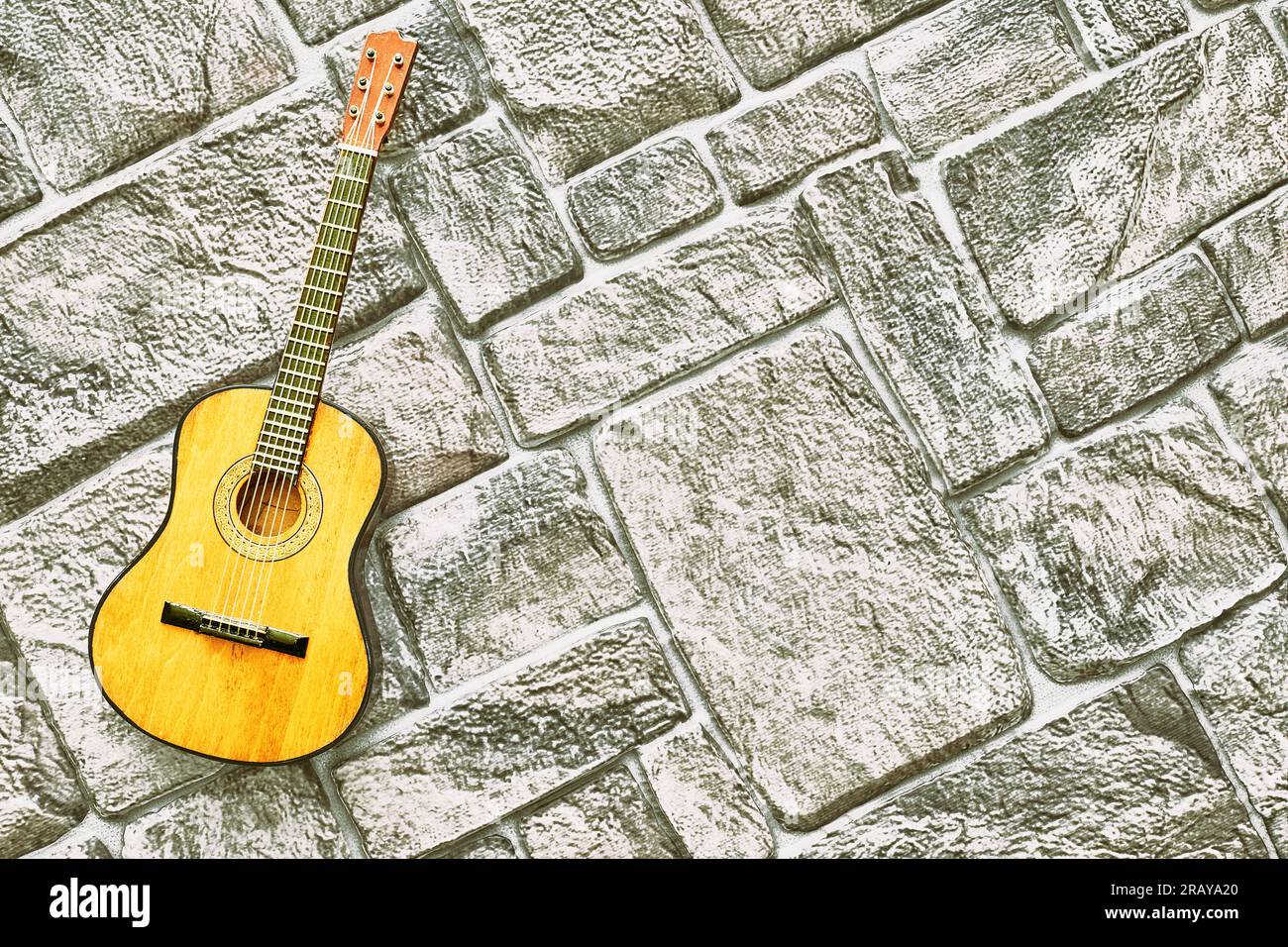 Yellow acoustic guitar on smoky gray pavement brick surface Stock Photo ...