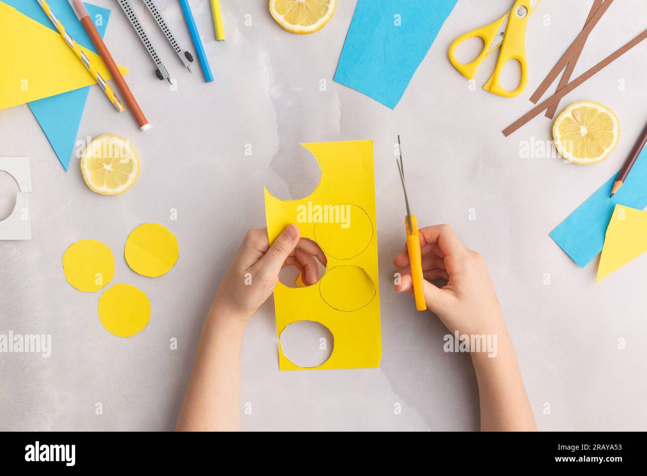 Paper lemonade with lemons. Children at home. Hands making DIY summer ...