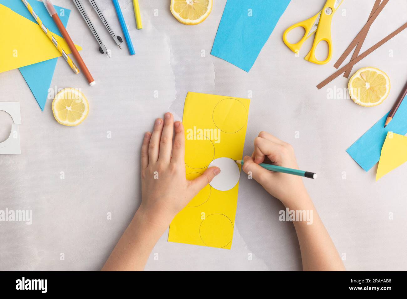 Paper lemonade with lemons. Children at home. Hands making DIY summer ...