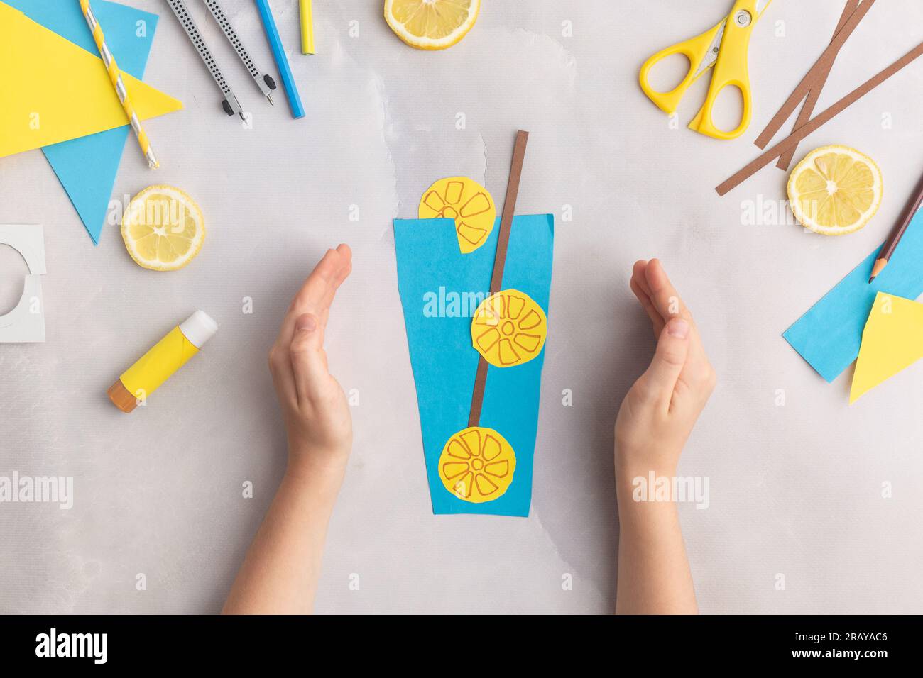Paper lemonade with lemons. Children at home. Hands making DIY summer ...