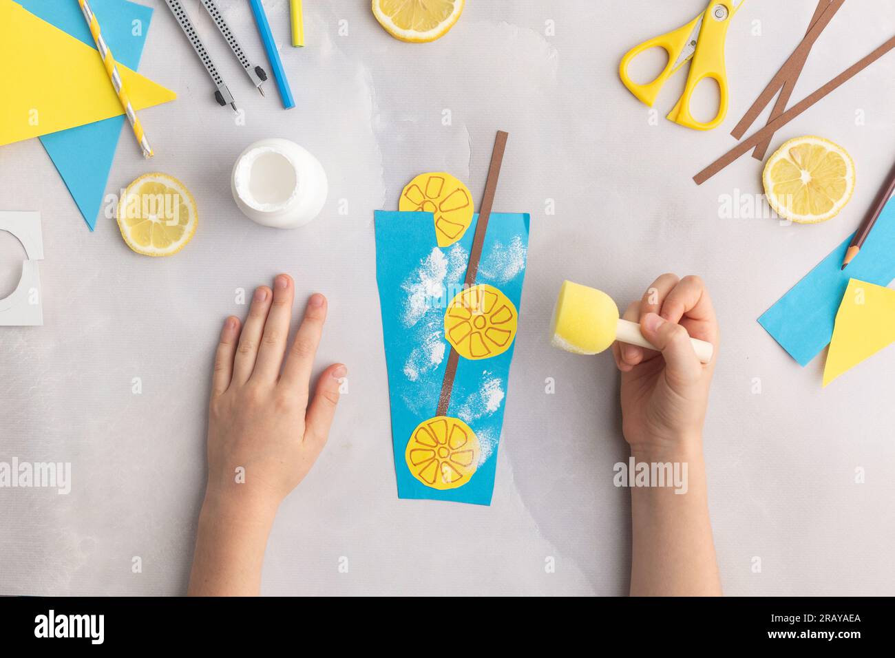 Paper lemonade with lemons. Children at home. Hands making DIY summer ...