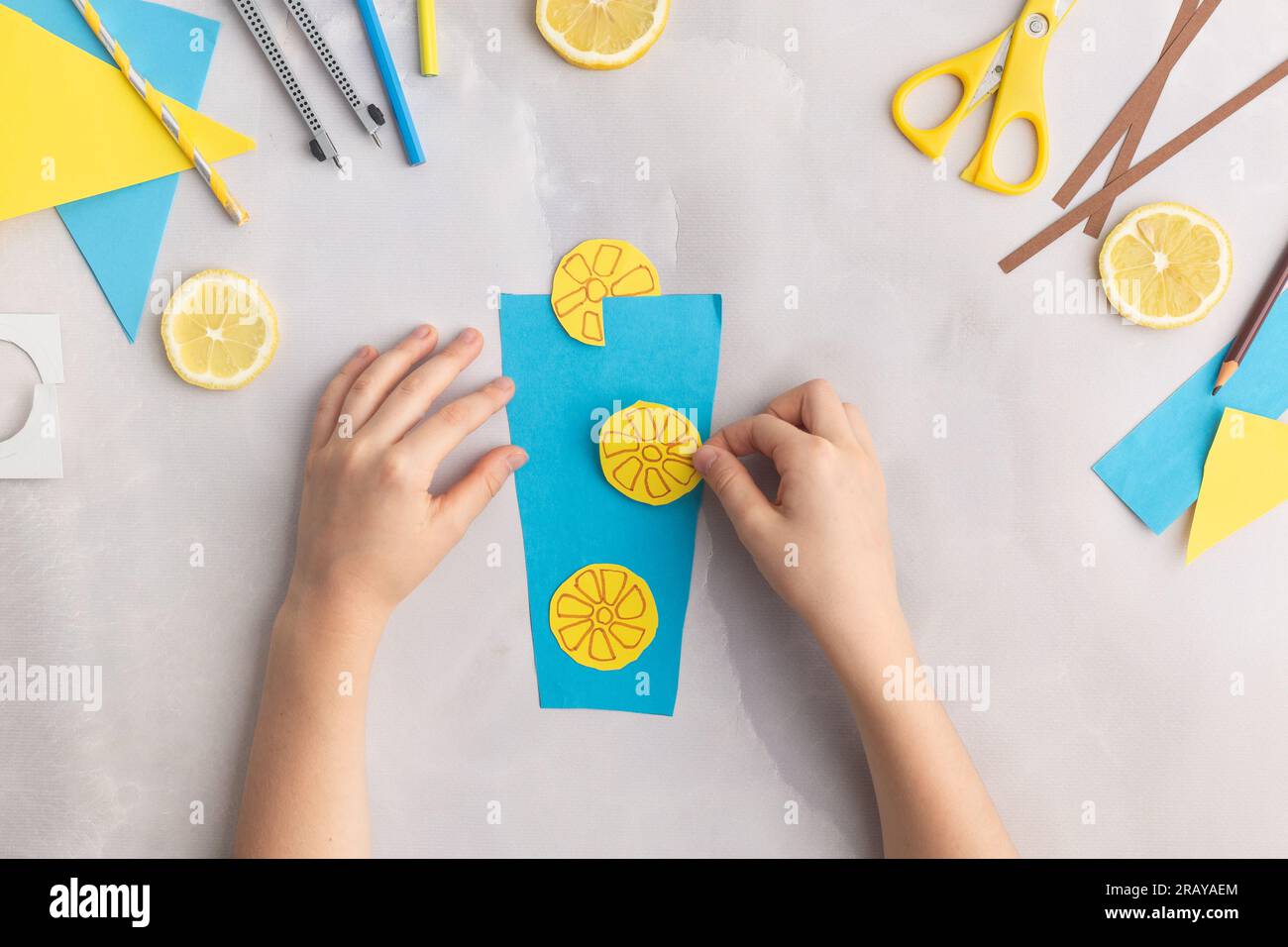 Paper lemonade with lemons. Children at home. Hands making DIY summer ...