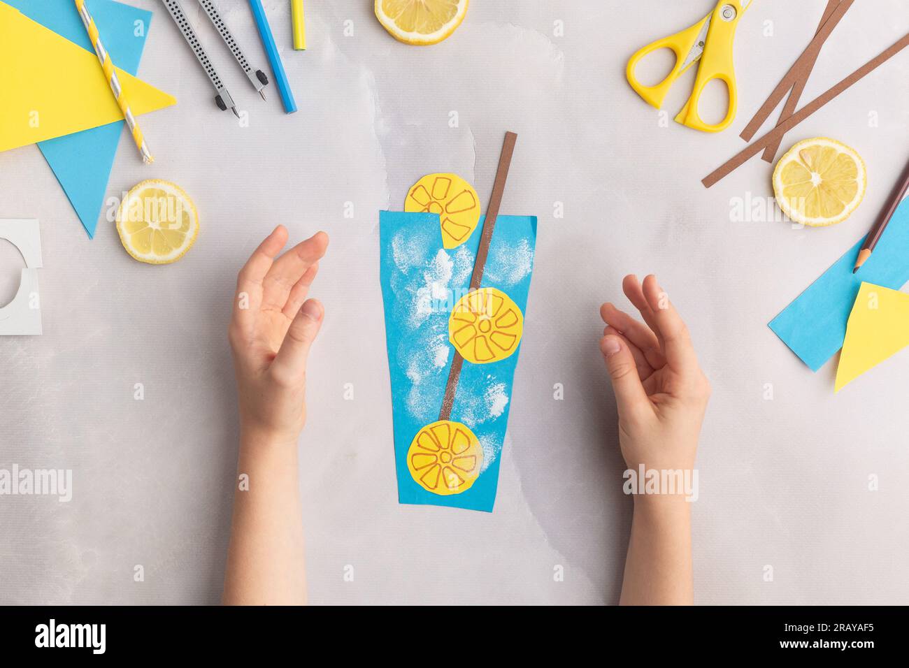 Paper lemonade with lemons. Children at home. Hands making DIY summer ...