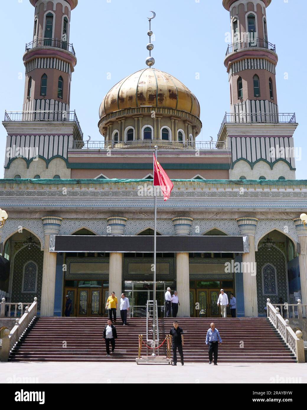 The Chinese national flag is hoisted in front of a mosque in Urumqi in ...