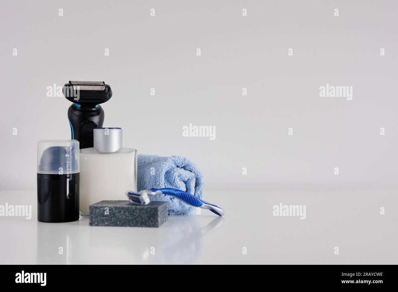Bottles of cosmetic products and razors for men on light background ...
